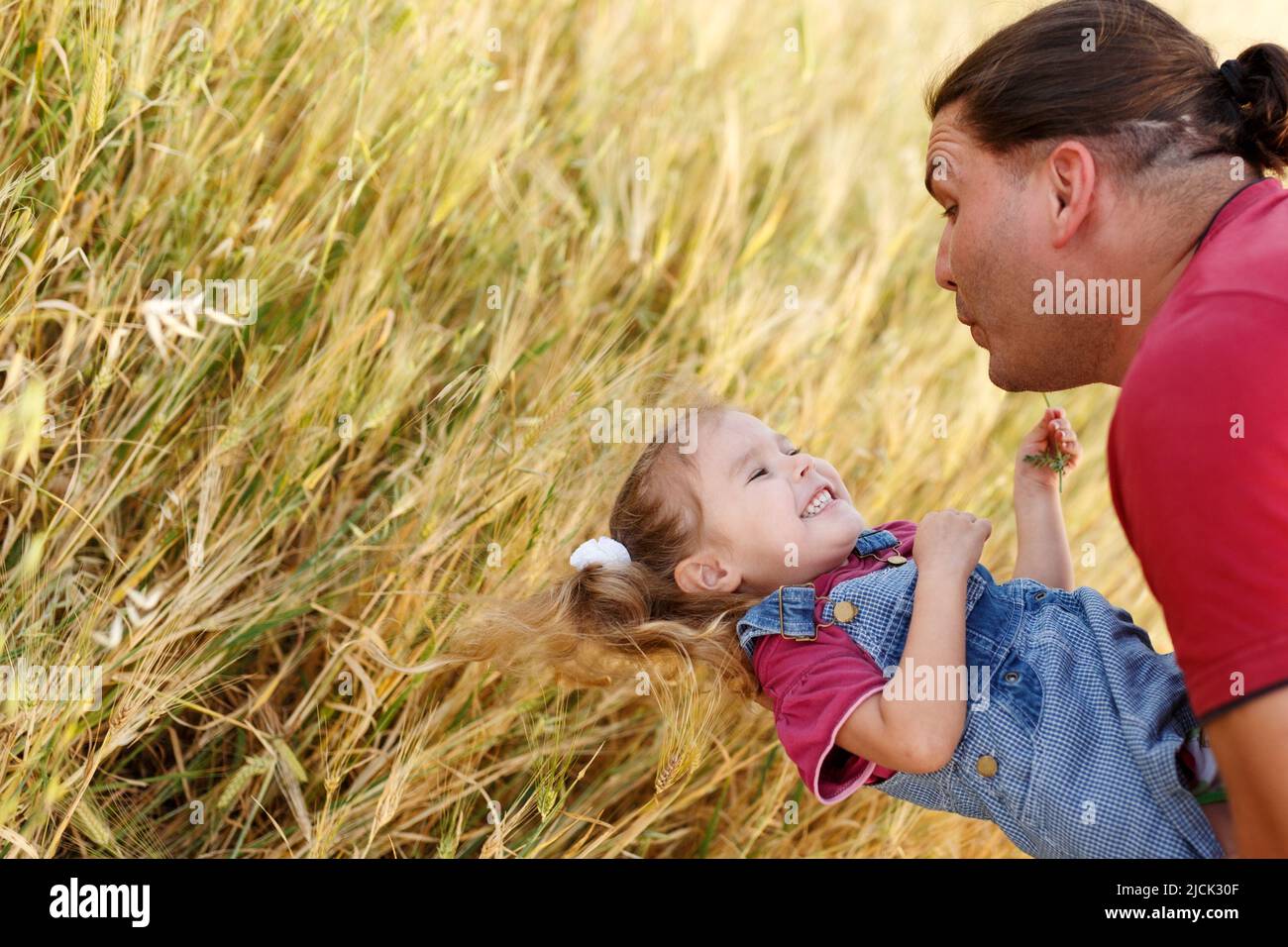 Happy father playing and carrying his daughter on hands.Mature man playing with his little ...