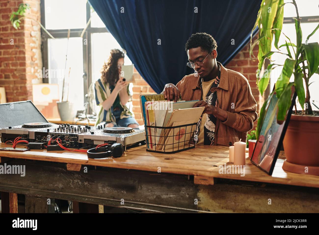 Young African American man looking through his collection of vynil ...