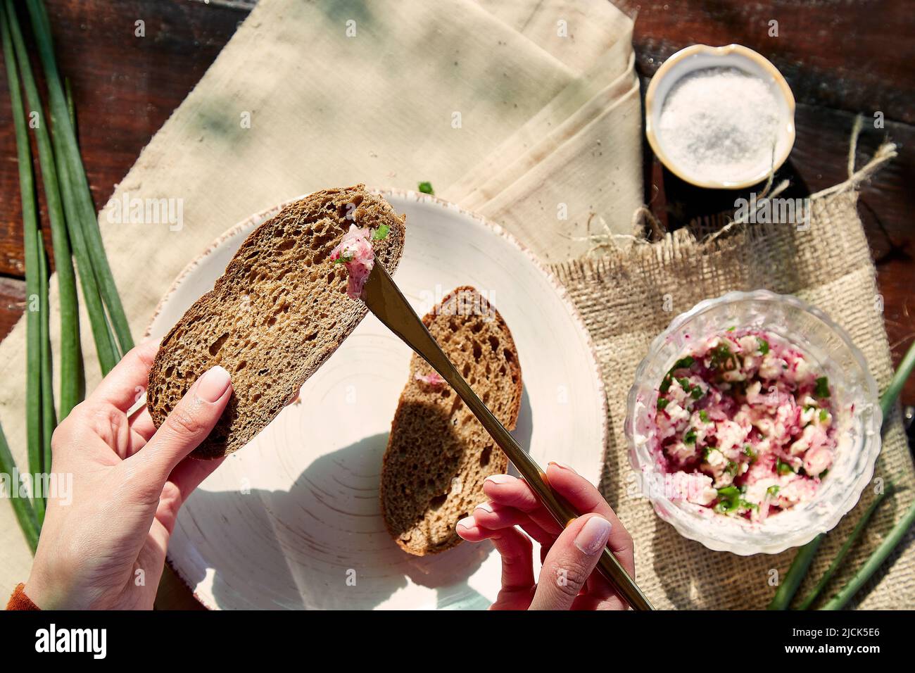 Smearing healthy radish on sourdough bread. Healthy snack - organic ...