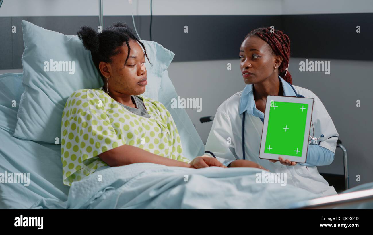 Medical specialist vertically holding green screen on tablet in ...