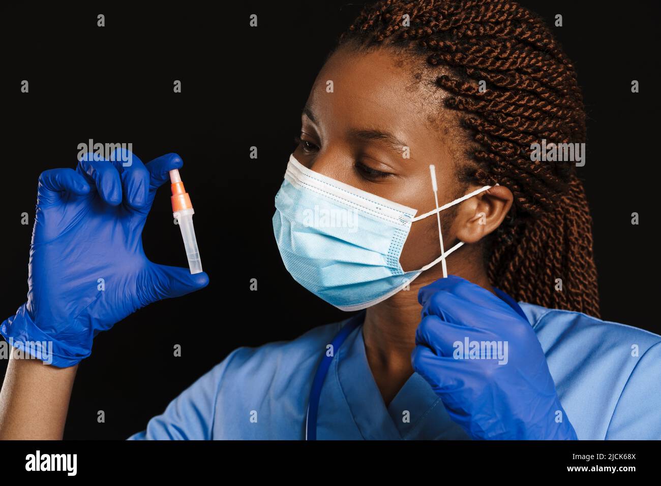 Black doctor wearing face mask posing with covid test isolated over ...
