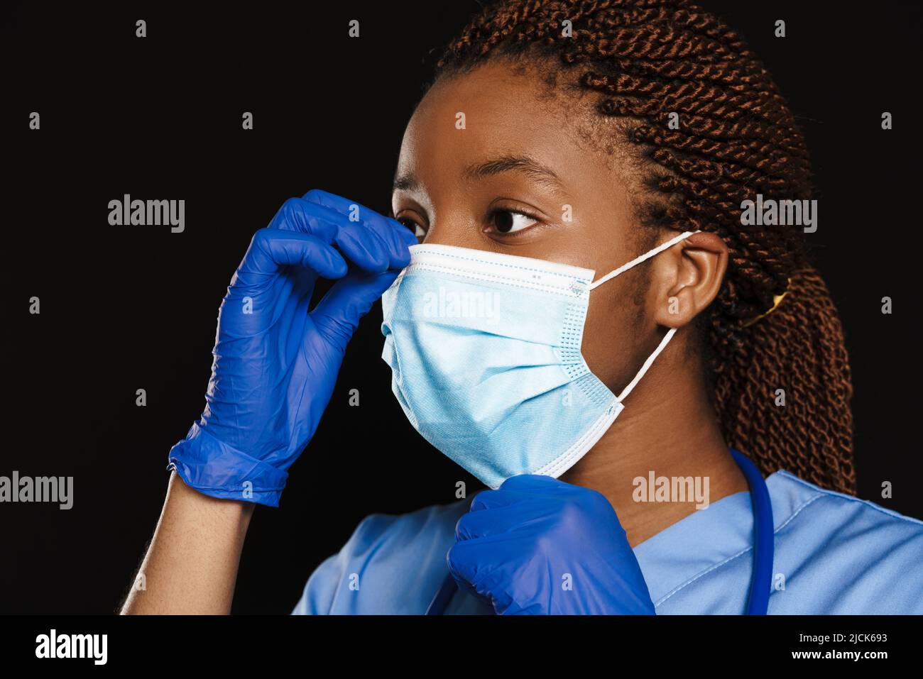 Black doctor wearing face mask posing and looking aside isolated over ...