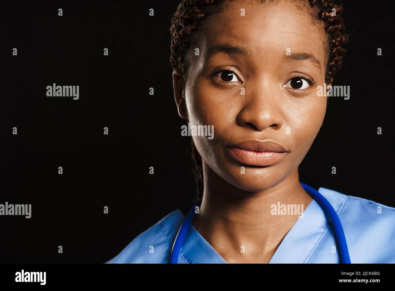 Black young doctor in face mask posing with stethoscope isolated over ...