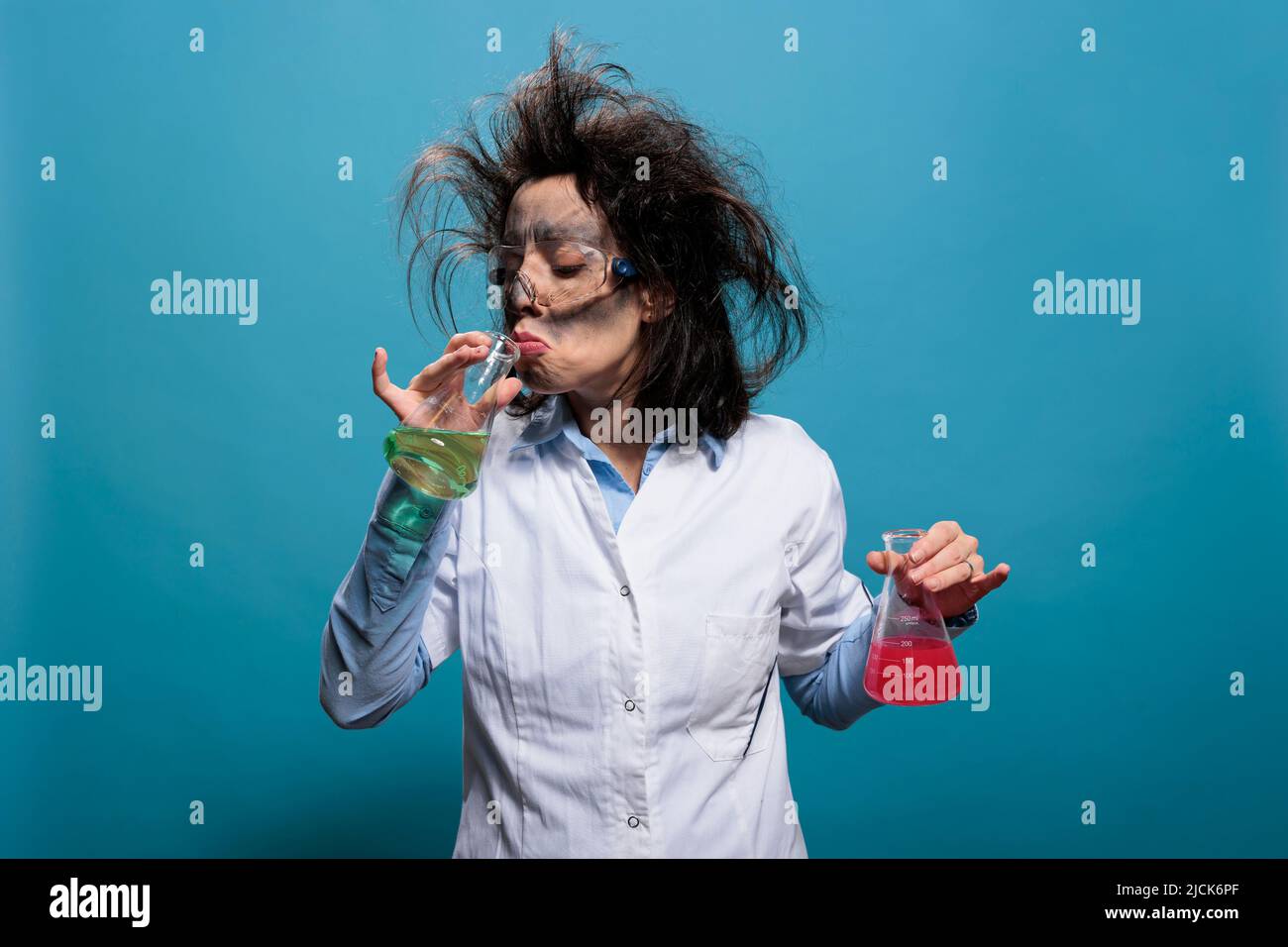 Wacky chemistry expert with messy hair and dirty face smelling glass ...