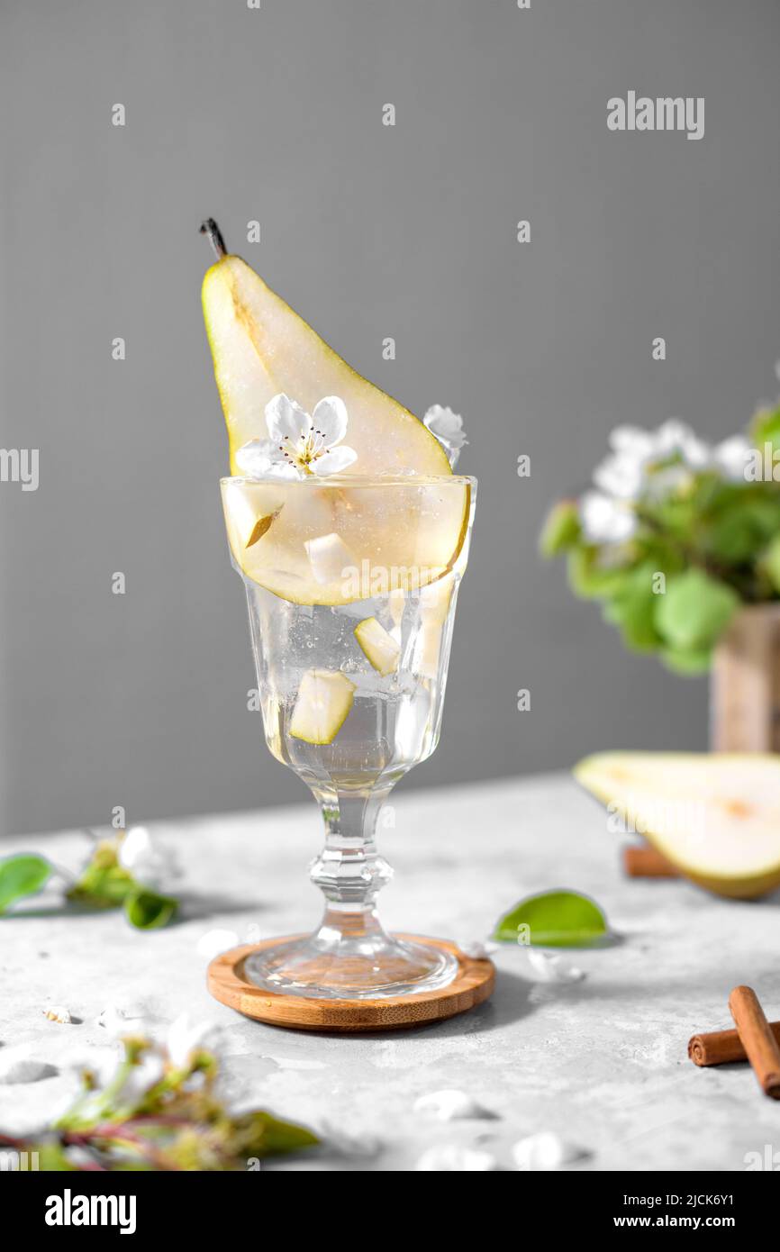 Pear cocktail in a glass decorated with fresh fruit and flowers on ...