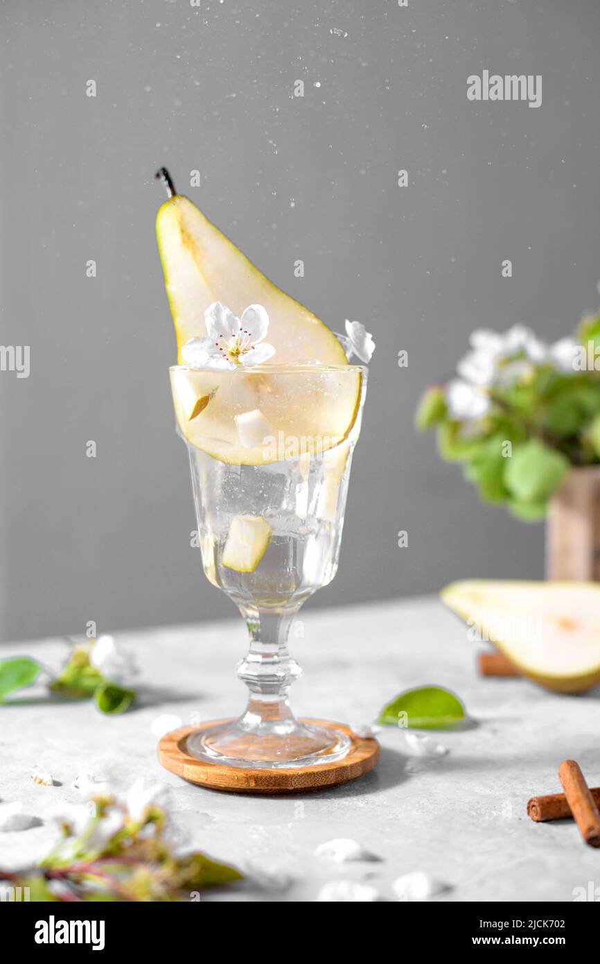 Pear cocktail in a glass decorated with fresh fruit and flowers on ...