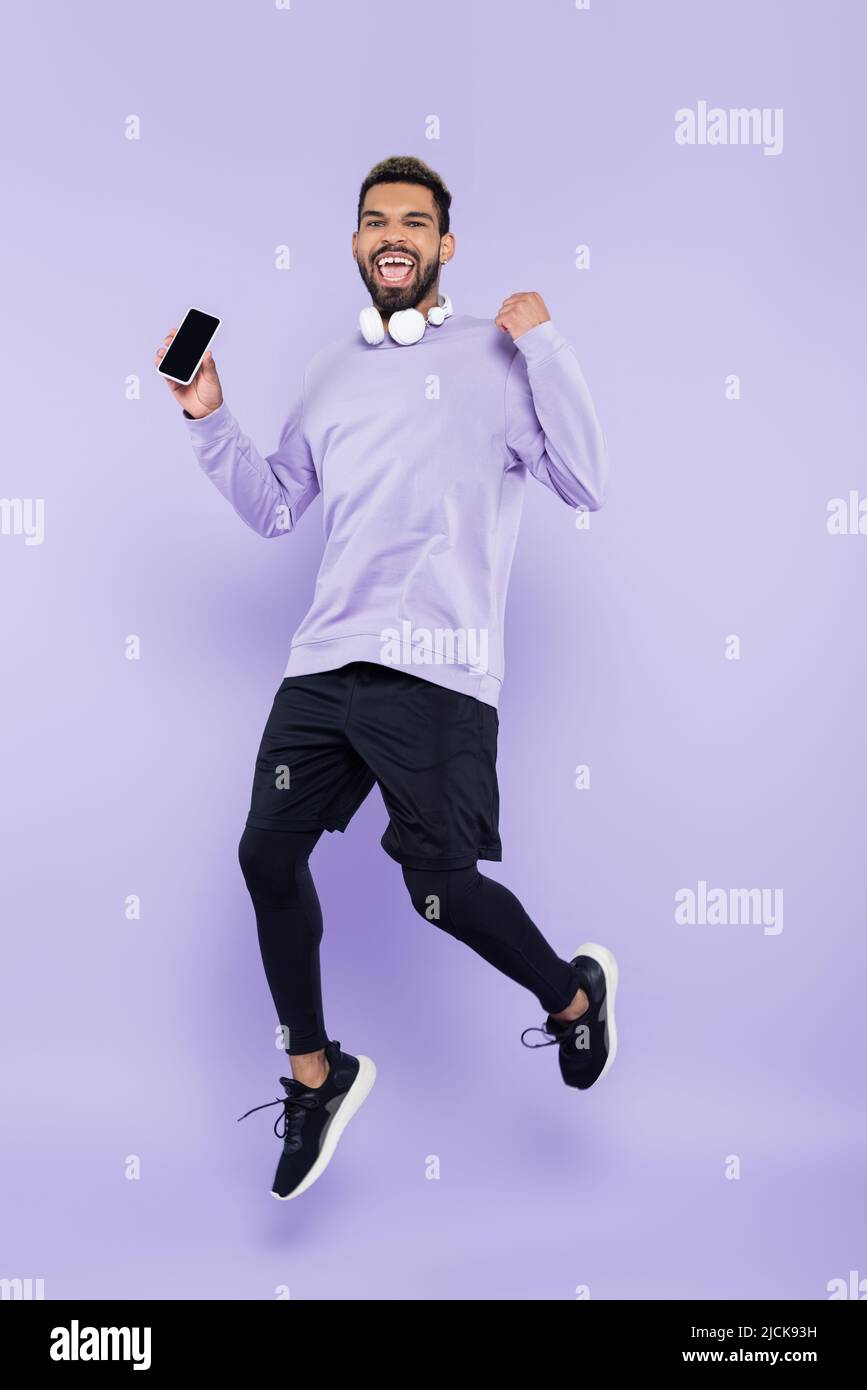 excited african american man with wireless headphones holding ...