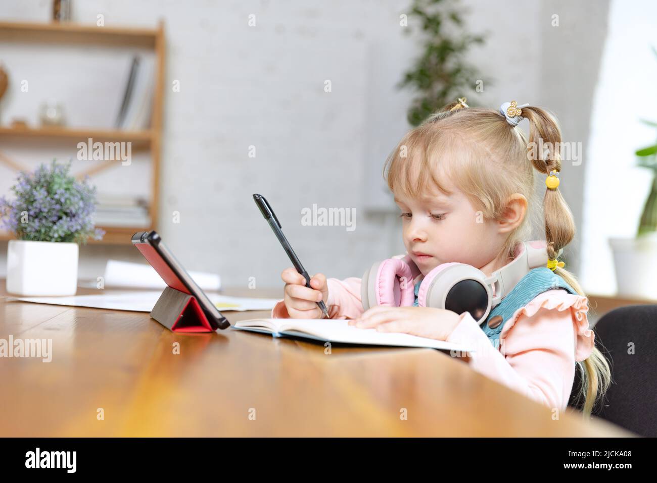Live portrait of cute little girl, preschool age kid leaning at home ...