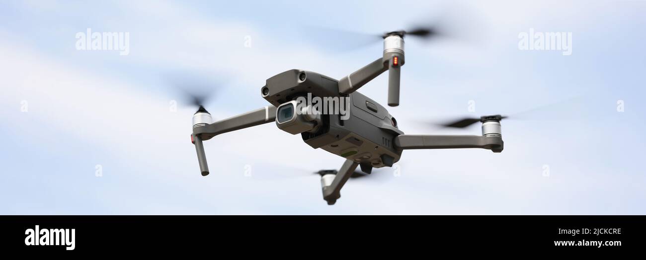 Modern drone device with remote controller flying and filming in air ...