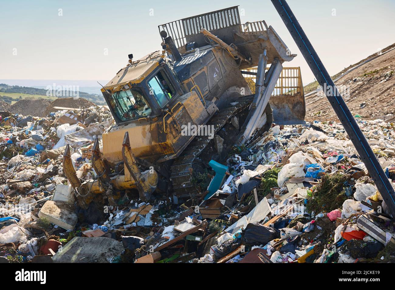Heavy machinery shredding garbage in an open air landfill. Waste Stock ...