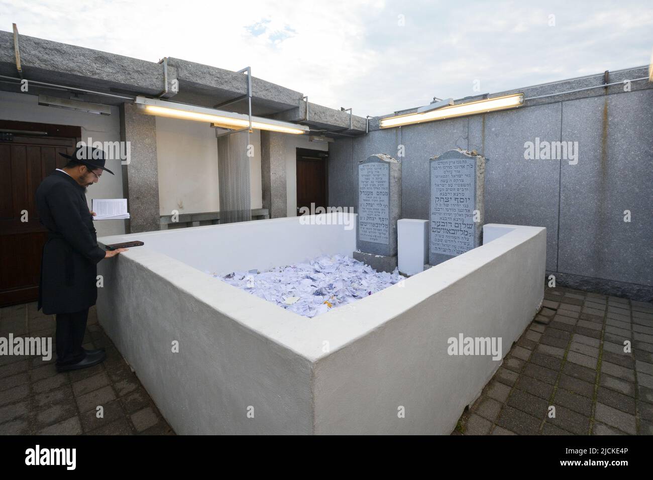 An orthodox jewish man prays at the Ohel at the headstones of the sixth ...