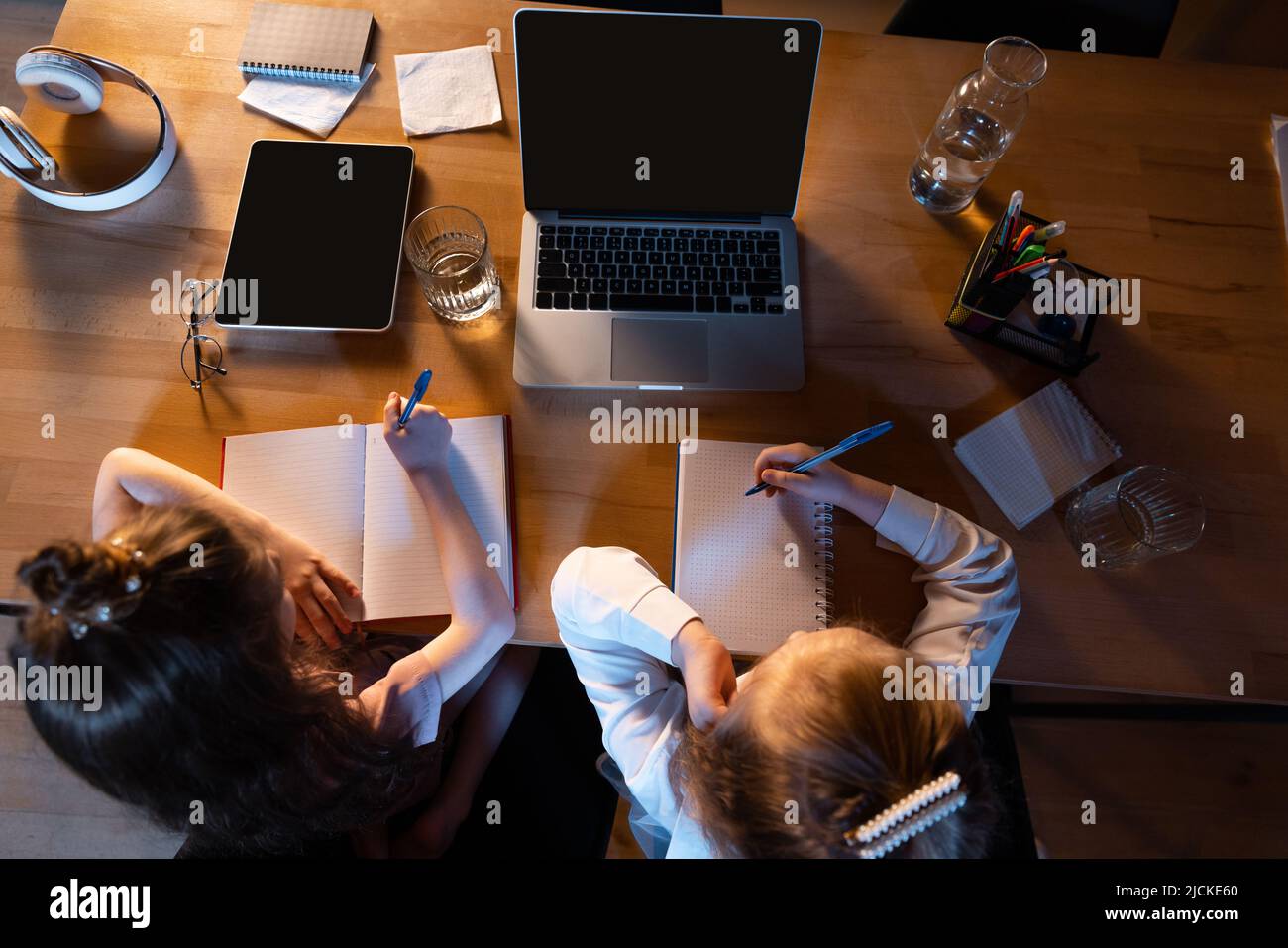 Aerial view of cute kids, sisters sitting at home play computer games ...