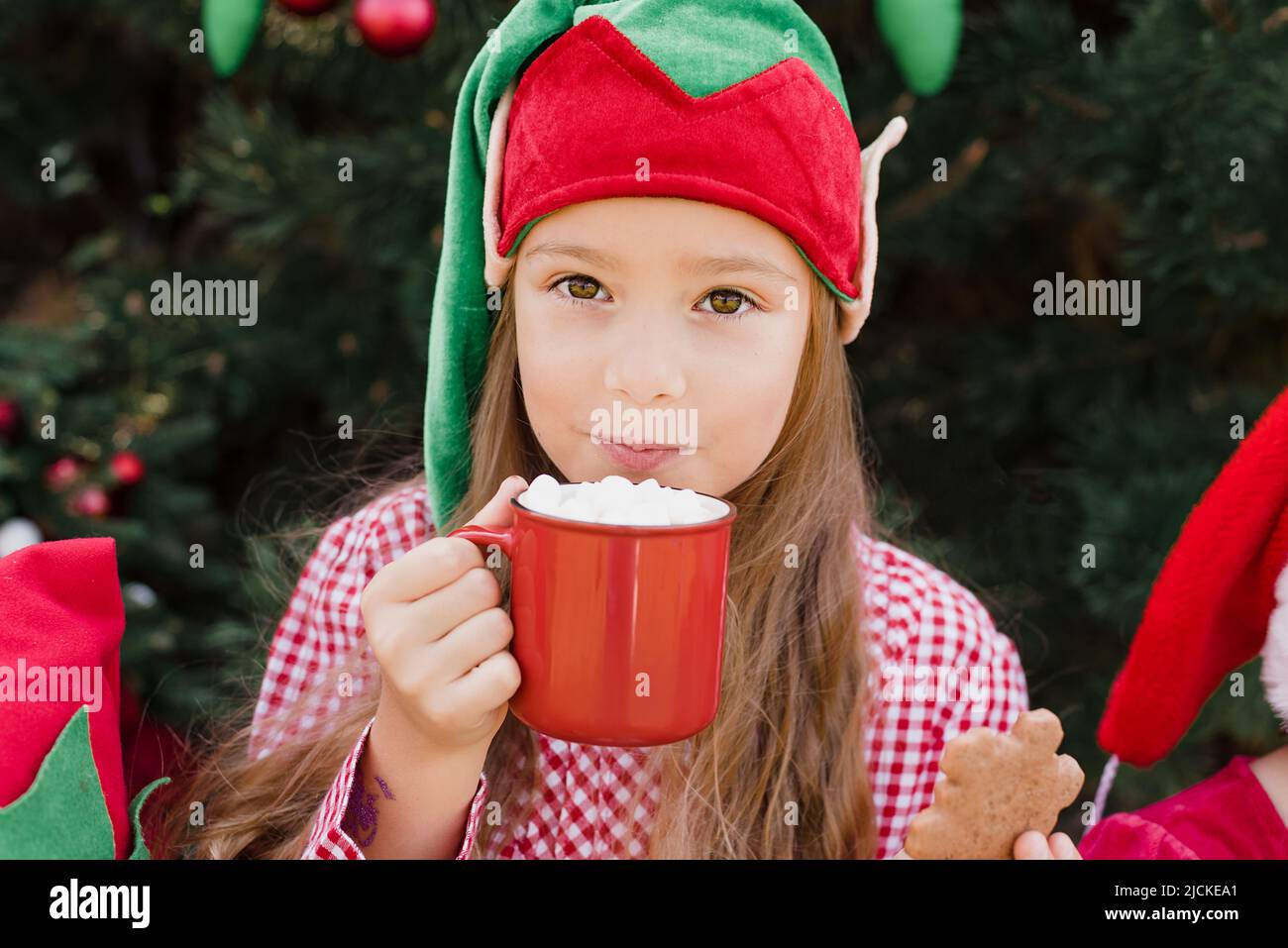 Merry Christmas. Portrait of funny child girl in Santa hat eating ...