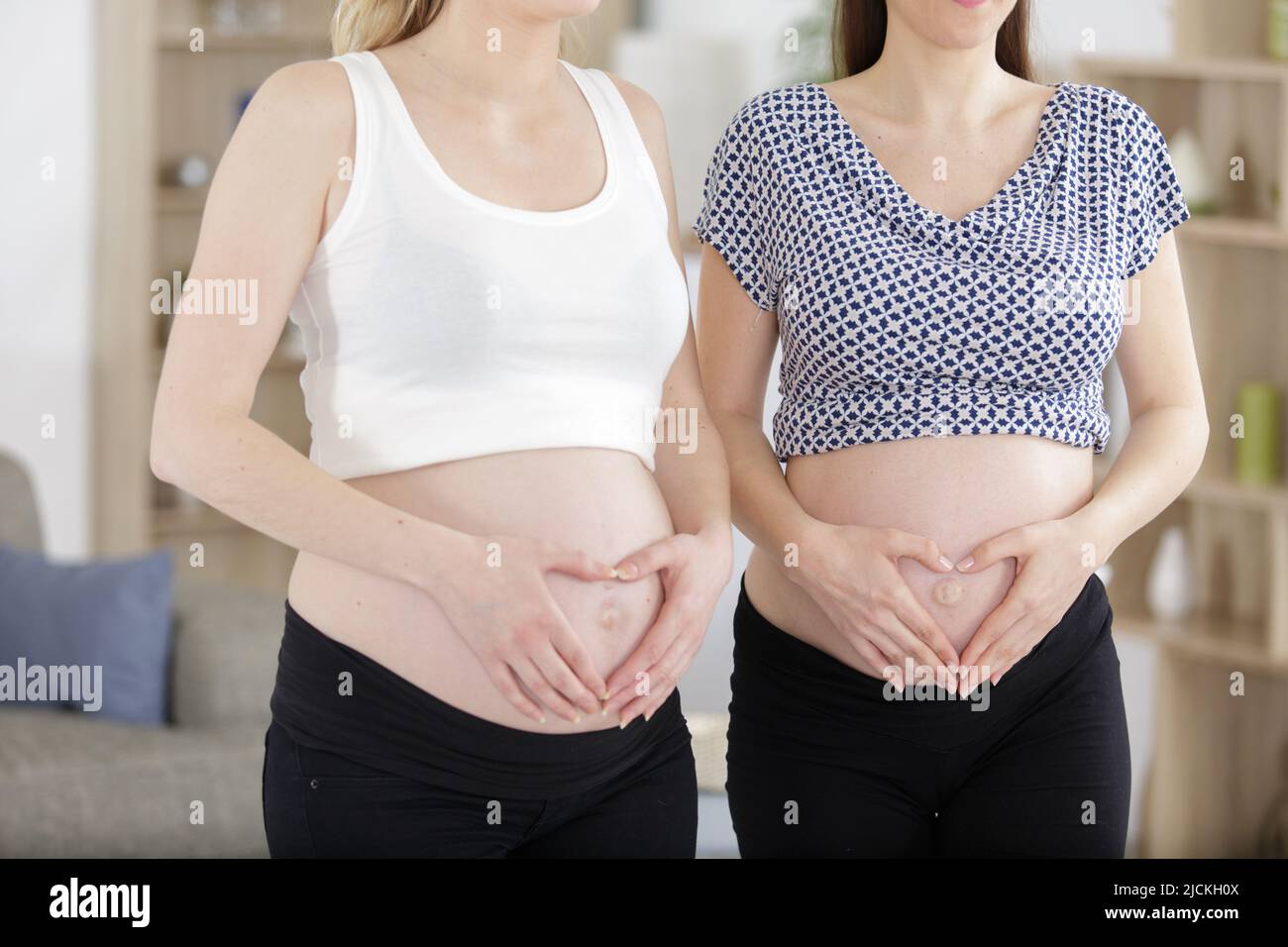 two women making heart shape on their pregnant bellies Stock Photo - Alamy