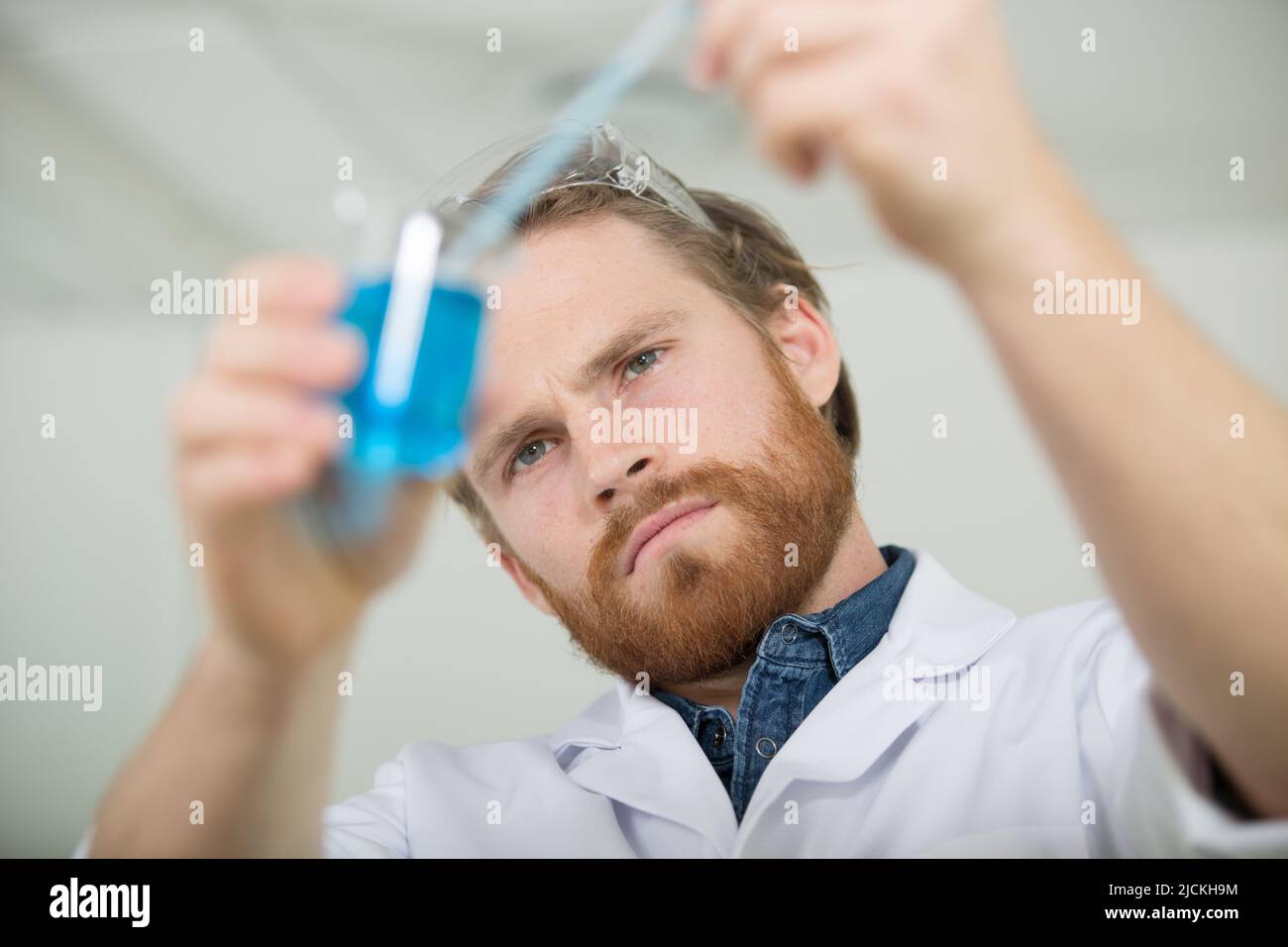 Scientist holding beaker hi-res stock photography and images - Alamy