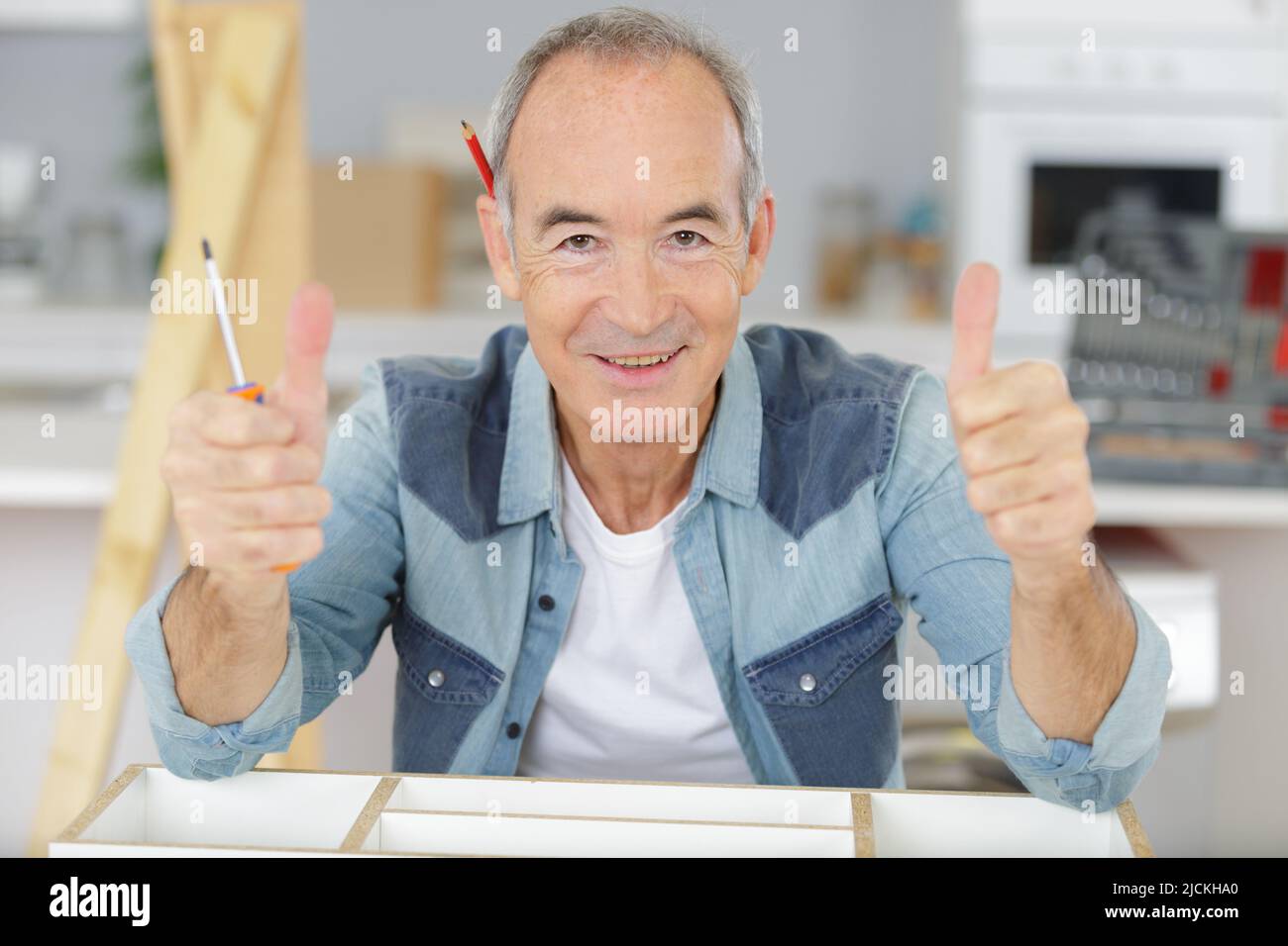 senior handyman giving thumbs up in the home Stock Photo - Alamy