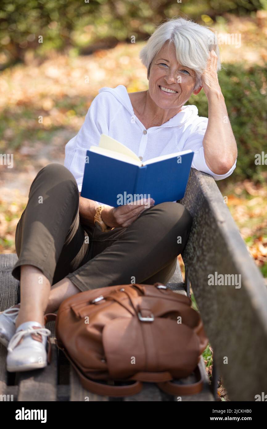 serious focused old lady reading novel in park Stock Photo - Alamy