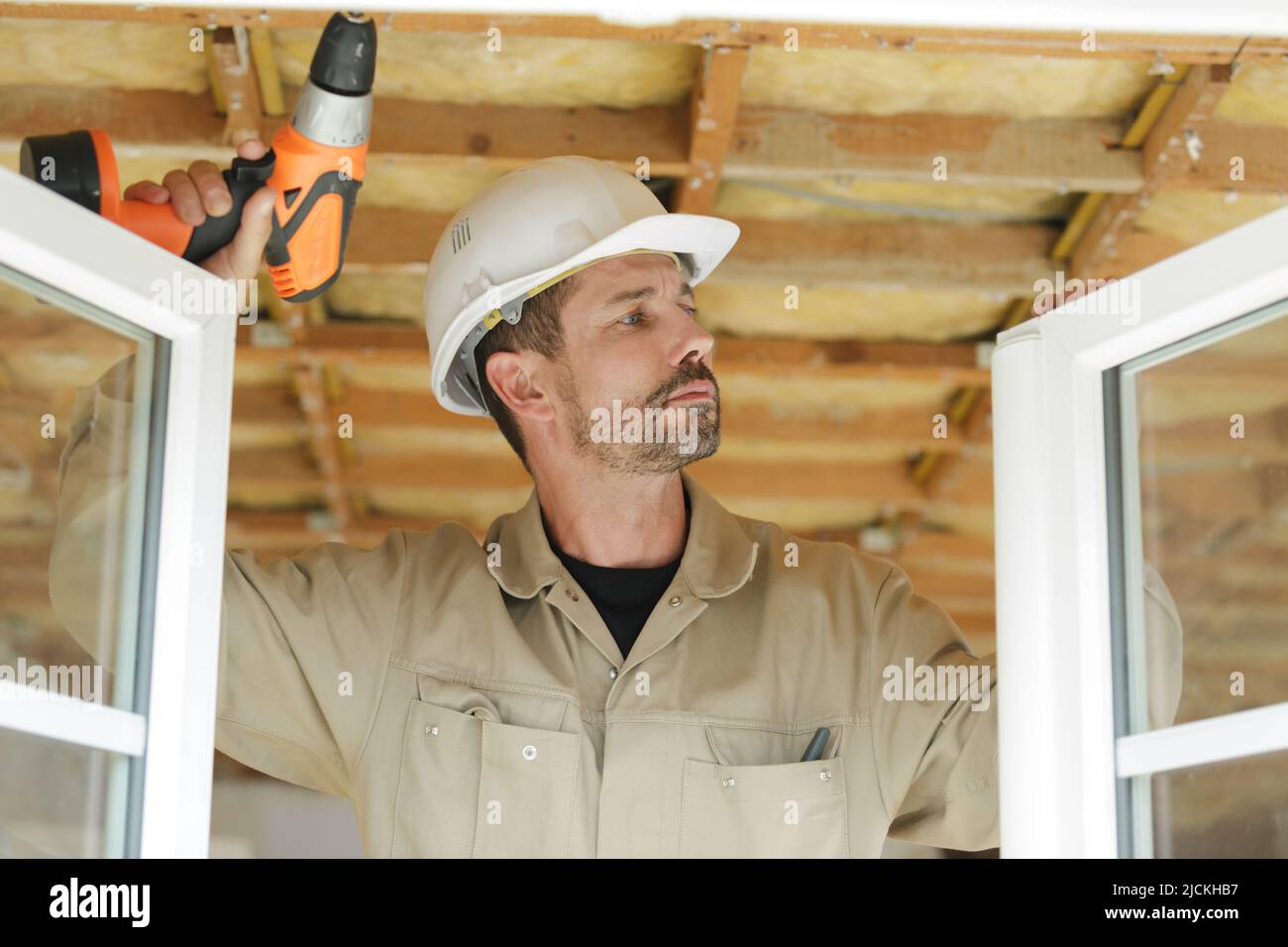 handsome man installing bay window in a new house Stock Photo - Alamy