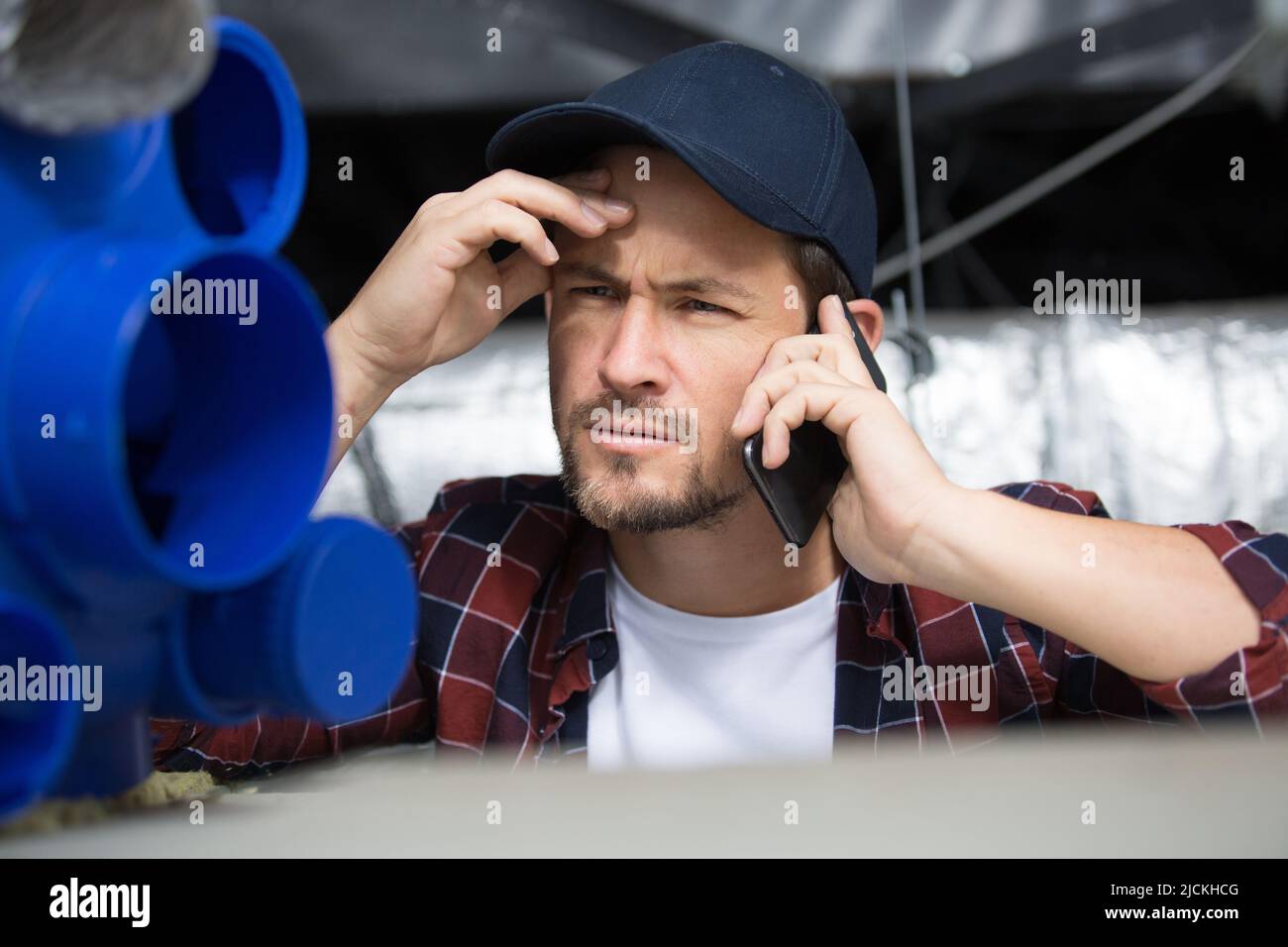 electrician confused by a plumbing project Stock Photo - Alamy