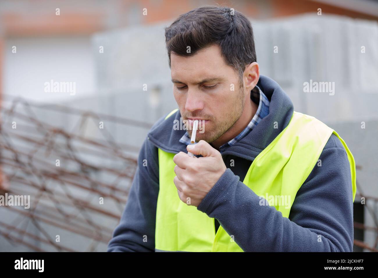 builder smoking cigarette on construction site Stock Photo - Alamy