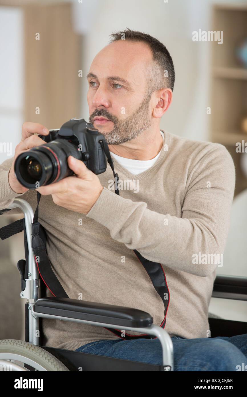 male disabled photographer holds camera in his hands Stock Photo - Alamy