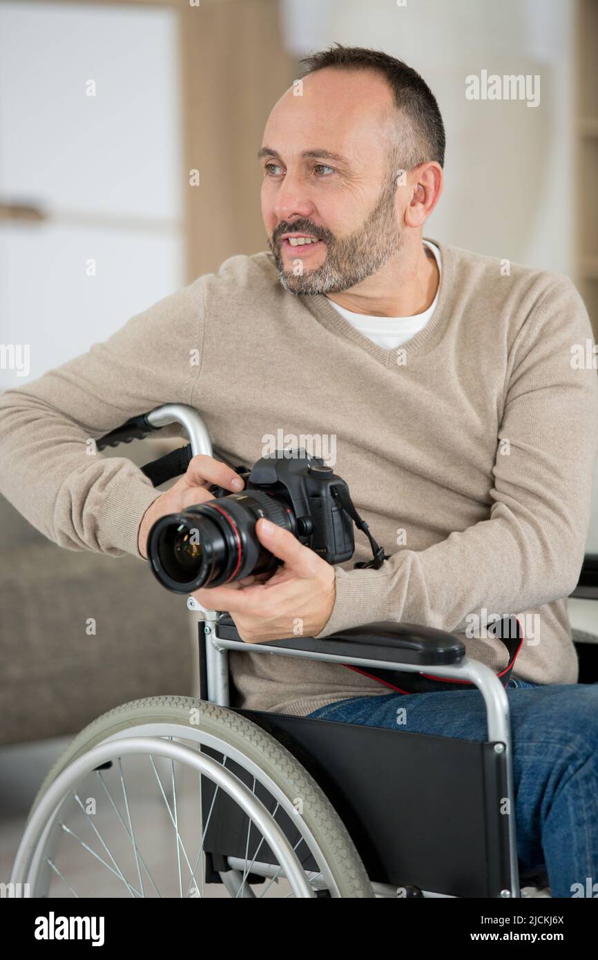 male photographer on wheelchair holding camera Stock Photo - Alamy