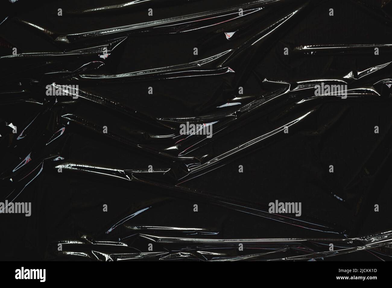 Crumpled wrinkled plastic cellophane. Transparent plastic wrap on black ...