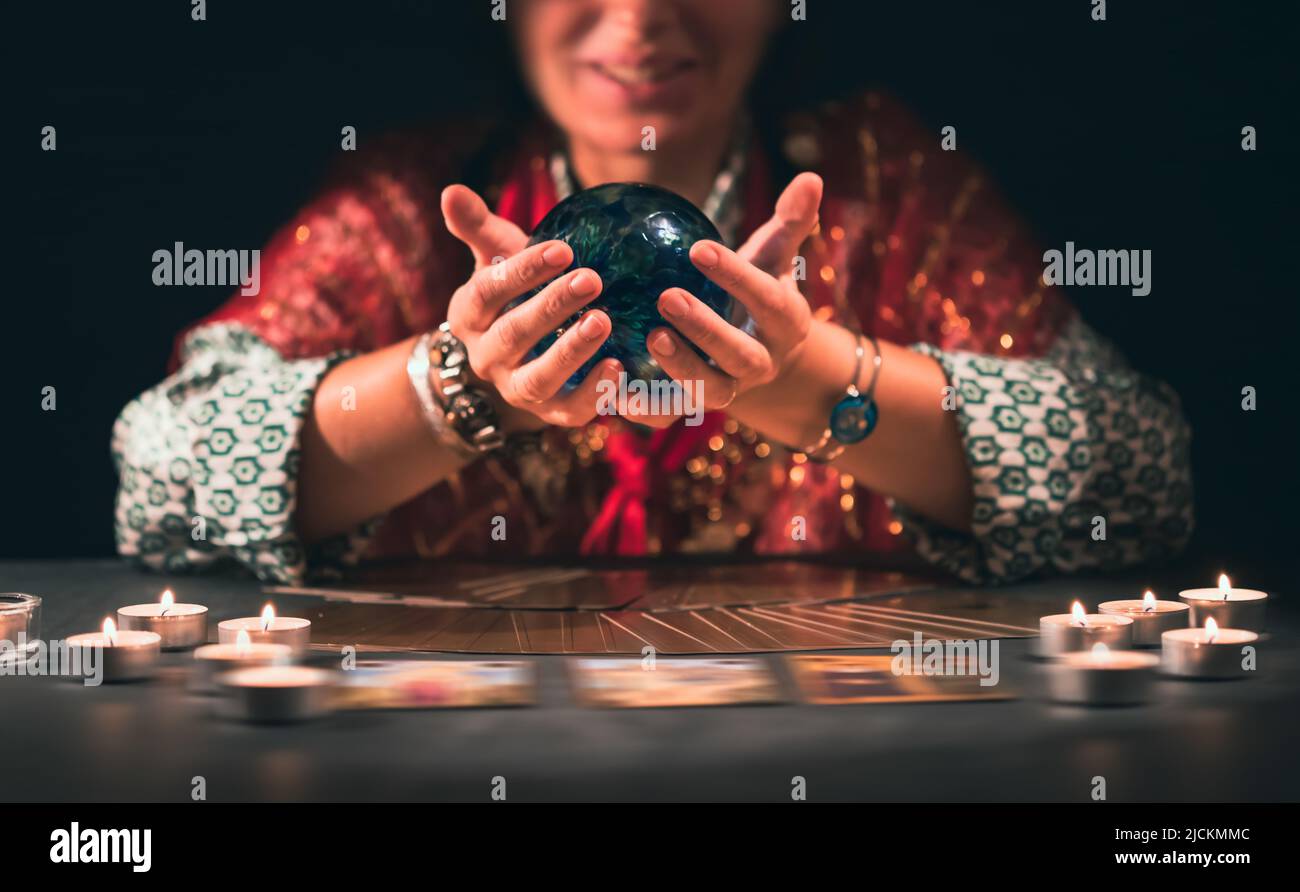 Fortune teller with tarot cards on table near burning candles.Tarot ...