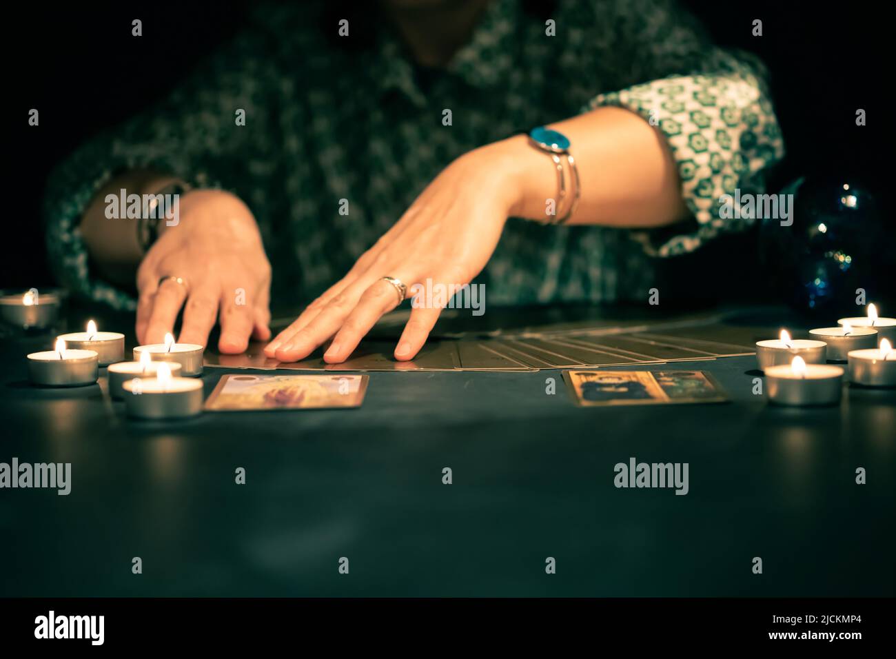 Fortune teller with tarot cards on table near burning candles.Tarot ...