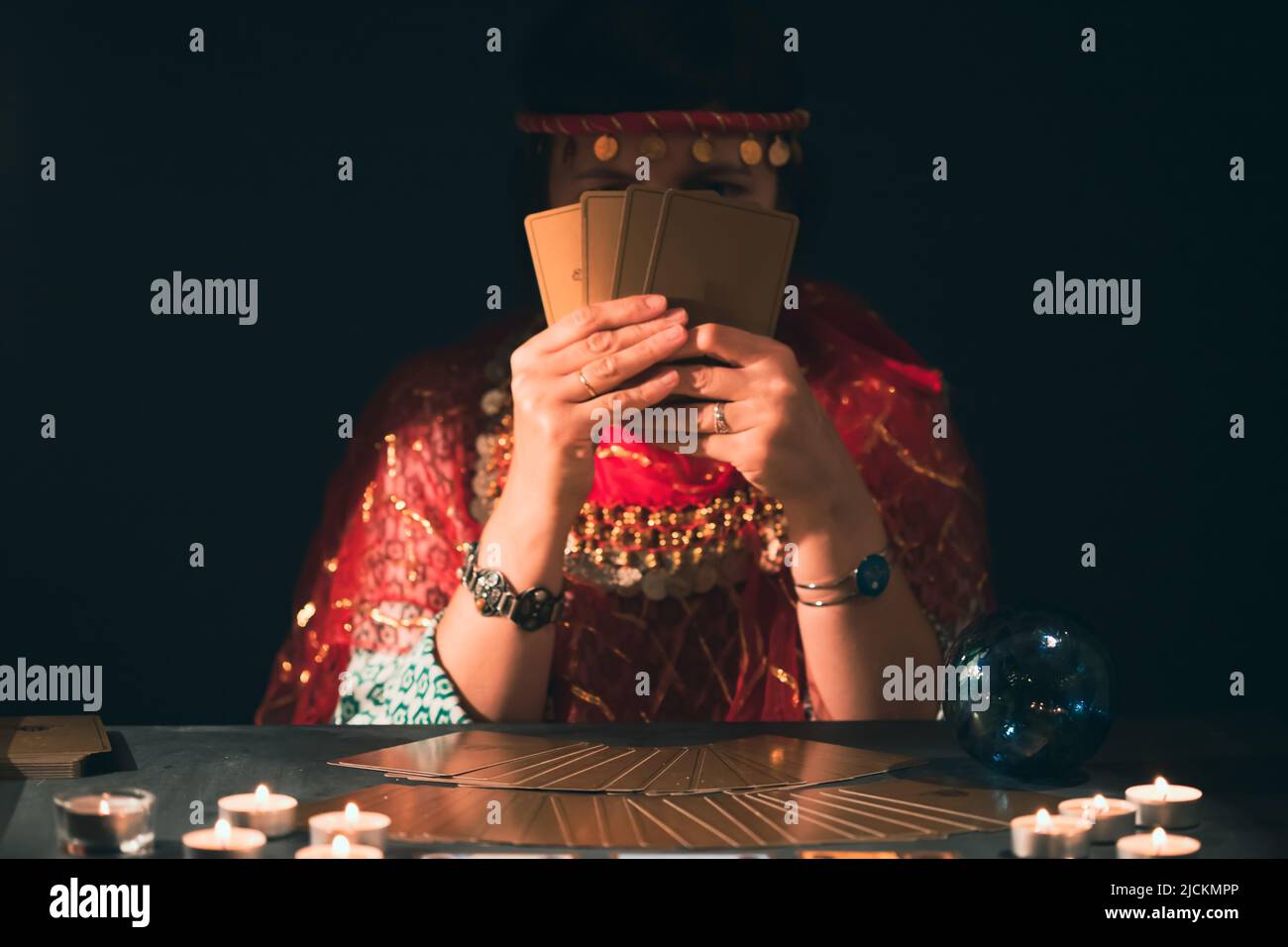 Fortune teller with tarot cards on table near burning candles.Tarot ...