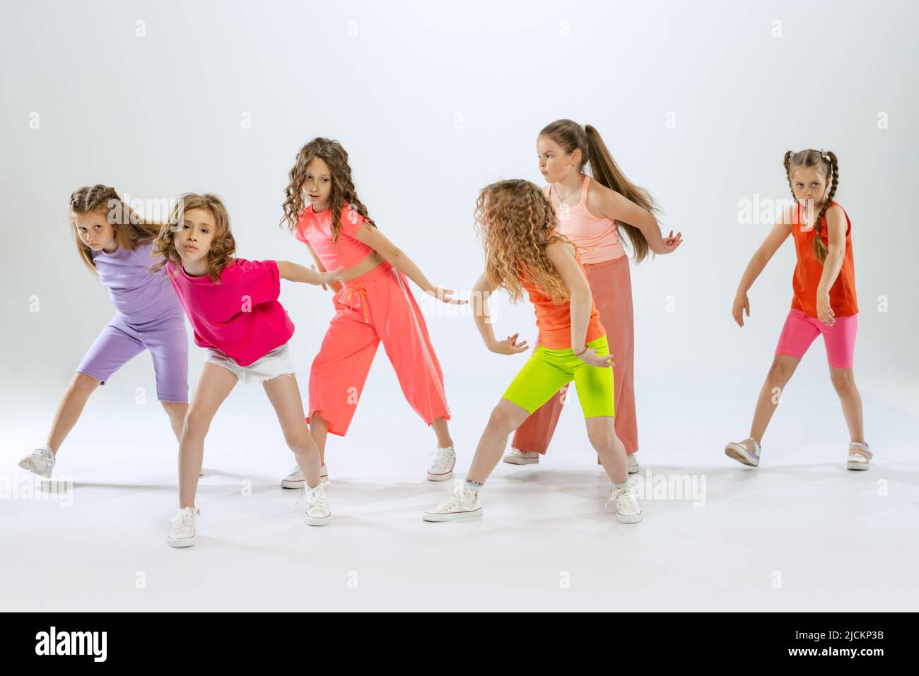 Dance group of happy, active little girls in bright colorful clothes ...