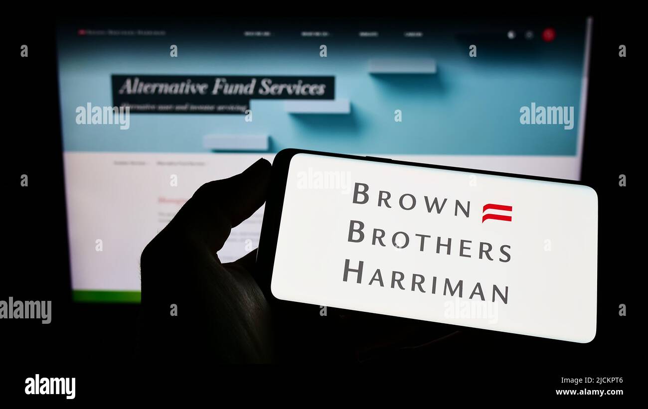 Person holding mobile phone with logo of US company Brown Brothers ...