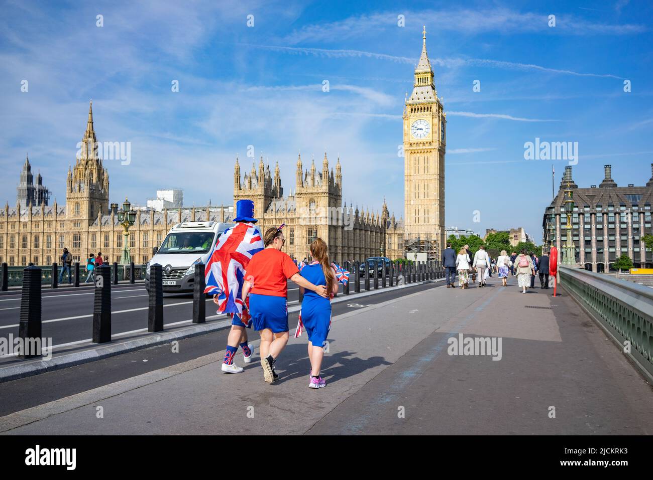 Family wearing union jack flag crossing Westminster Bridge over the ...