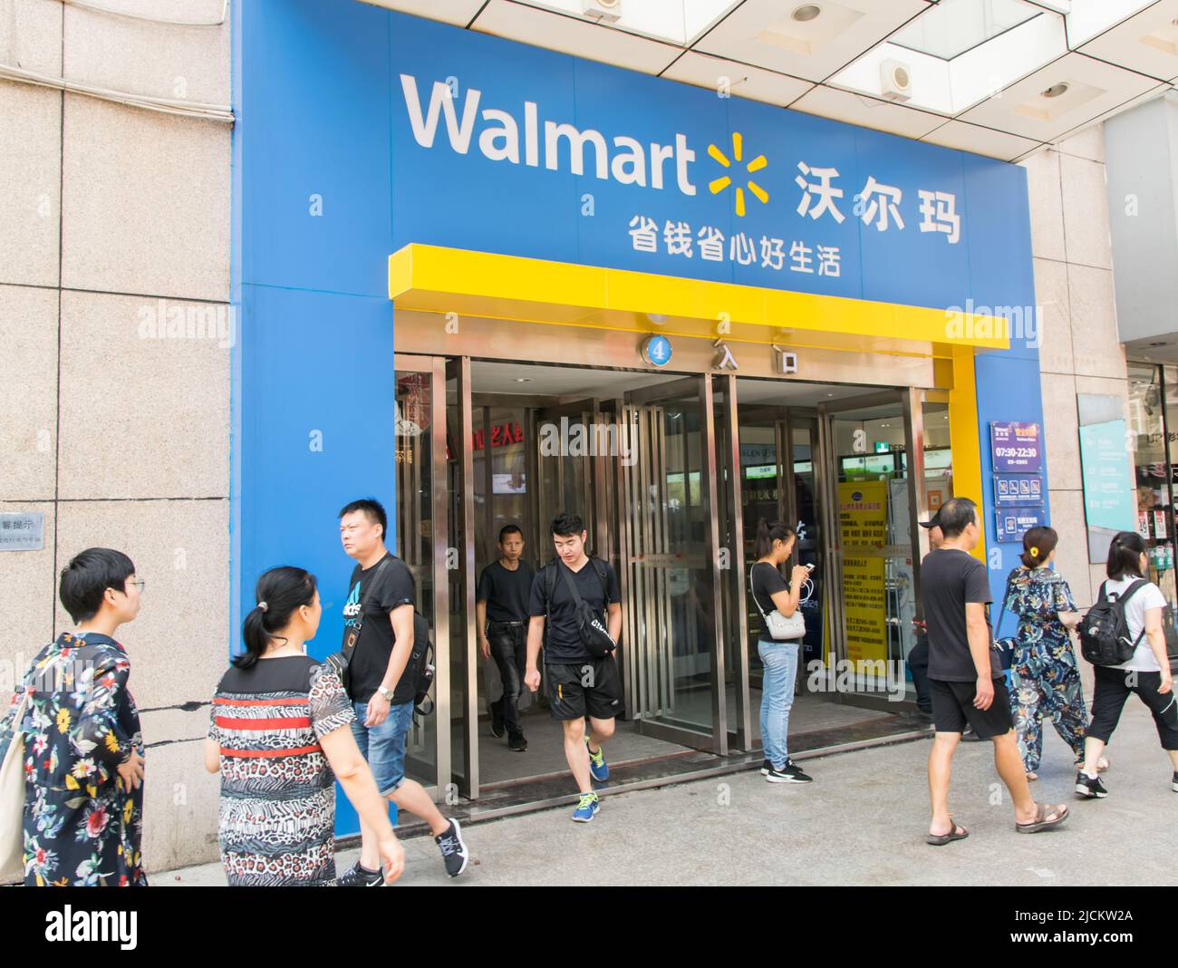 People coming in, coming out and passing by the entrance of a Walmart ...