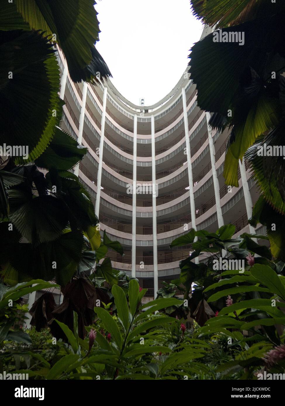Exterior of an oval building with small area for plant and flowers ...