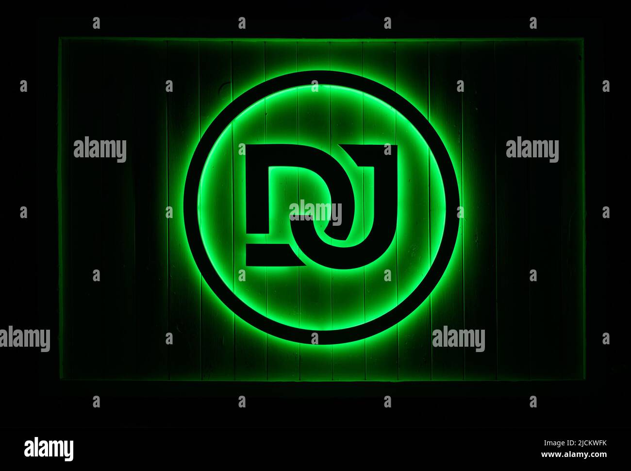 DJ sign with green neon illumination hanging on black wall Stock Photo ...