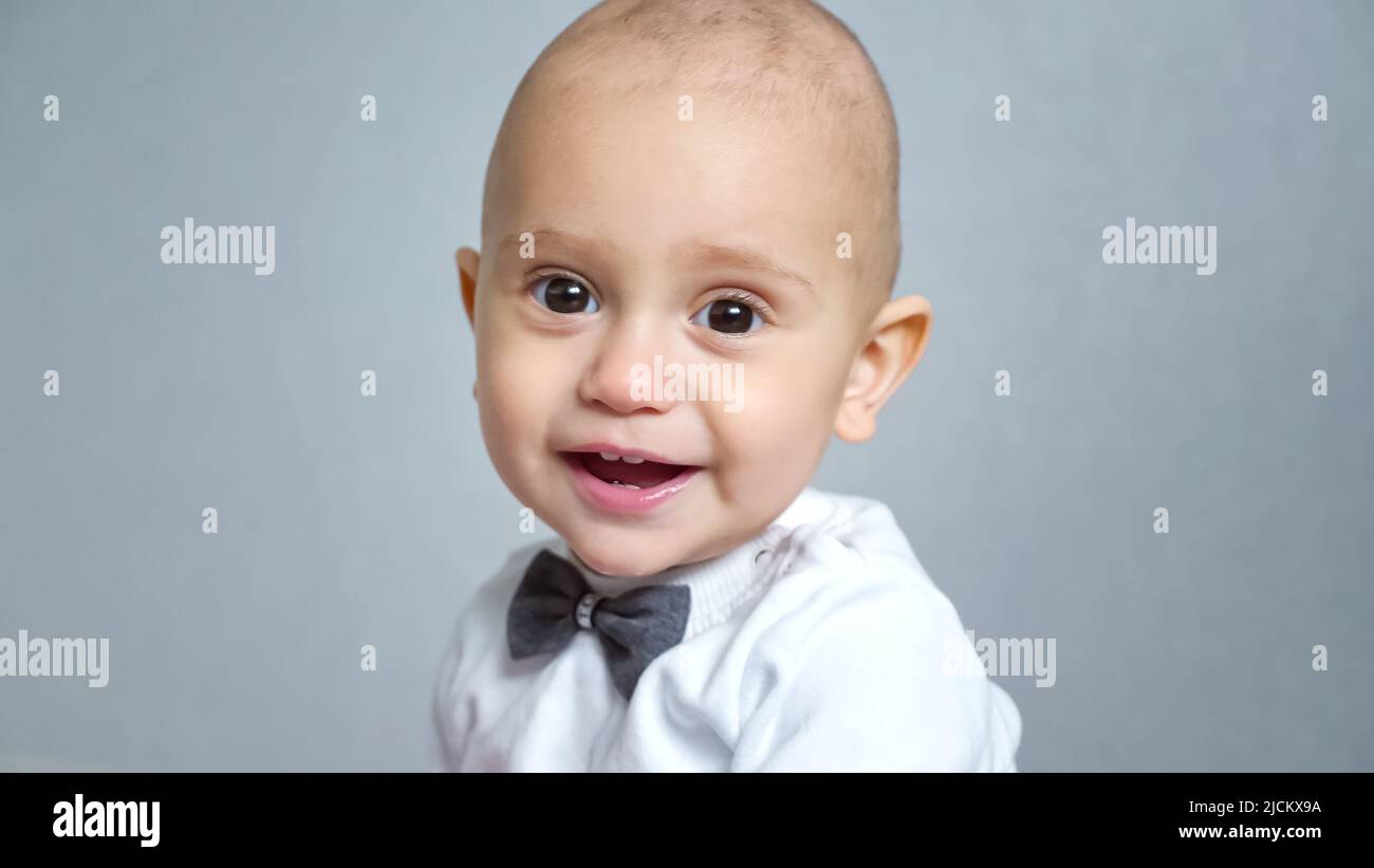 Little boy with bow tie looks at camera and smiles cutely Stock Photo ...