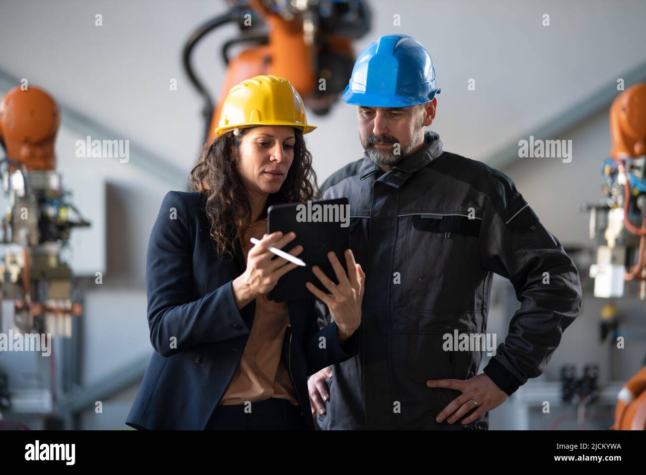 Female engineering manager and mechanic worker doing routine check up ...