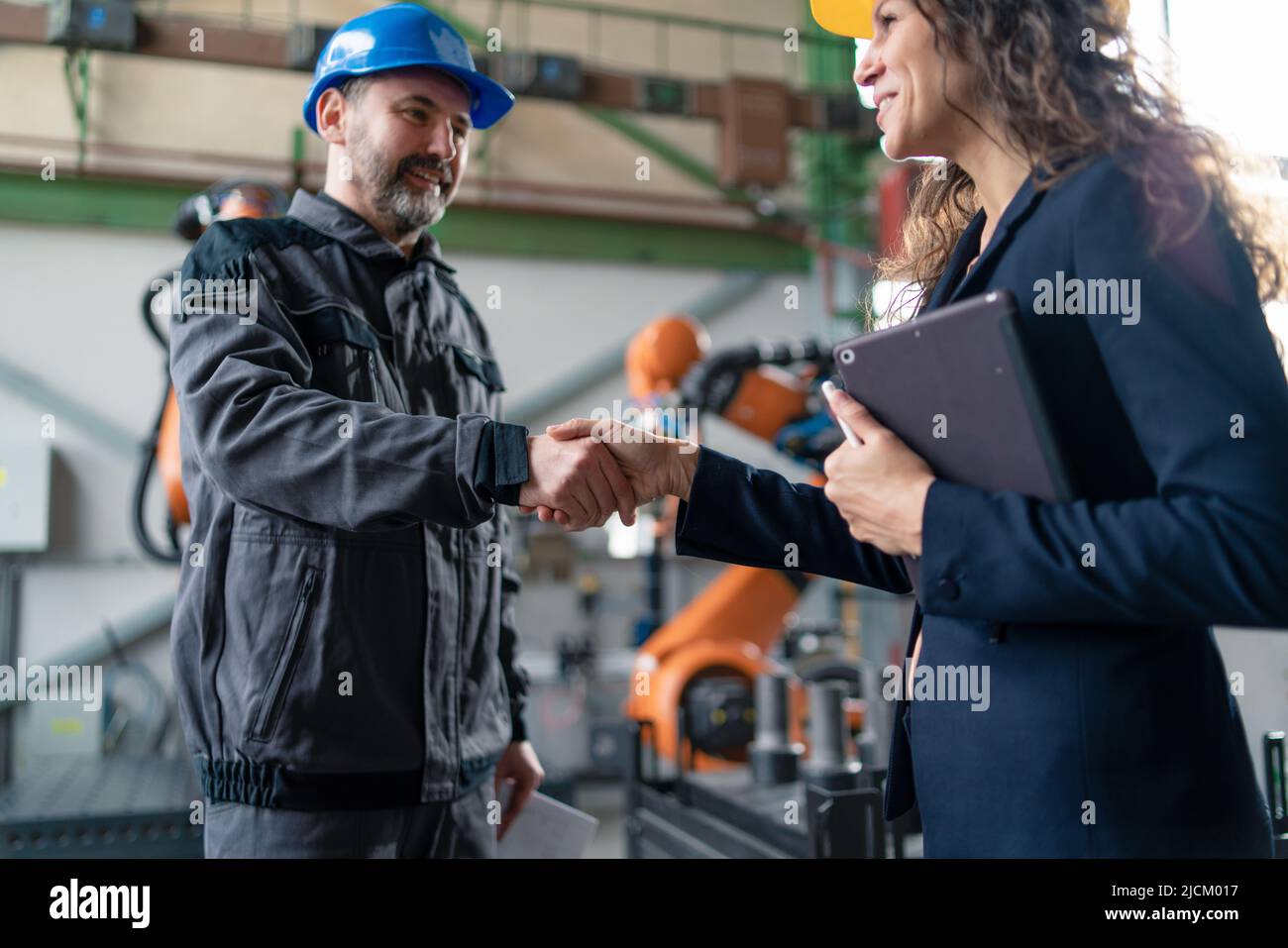 Female engineering manager and mechanic worker fist bumping in ...
