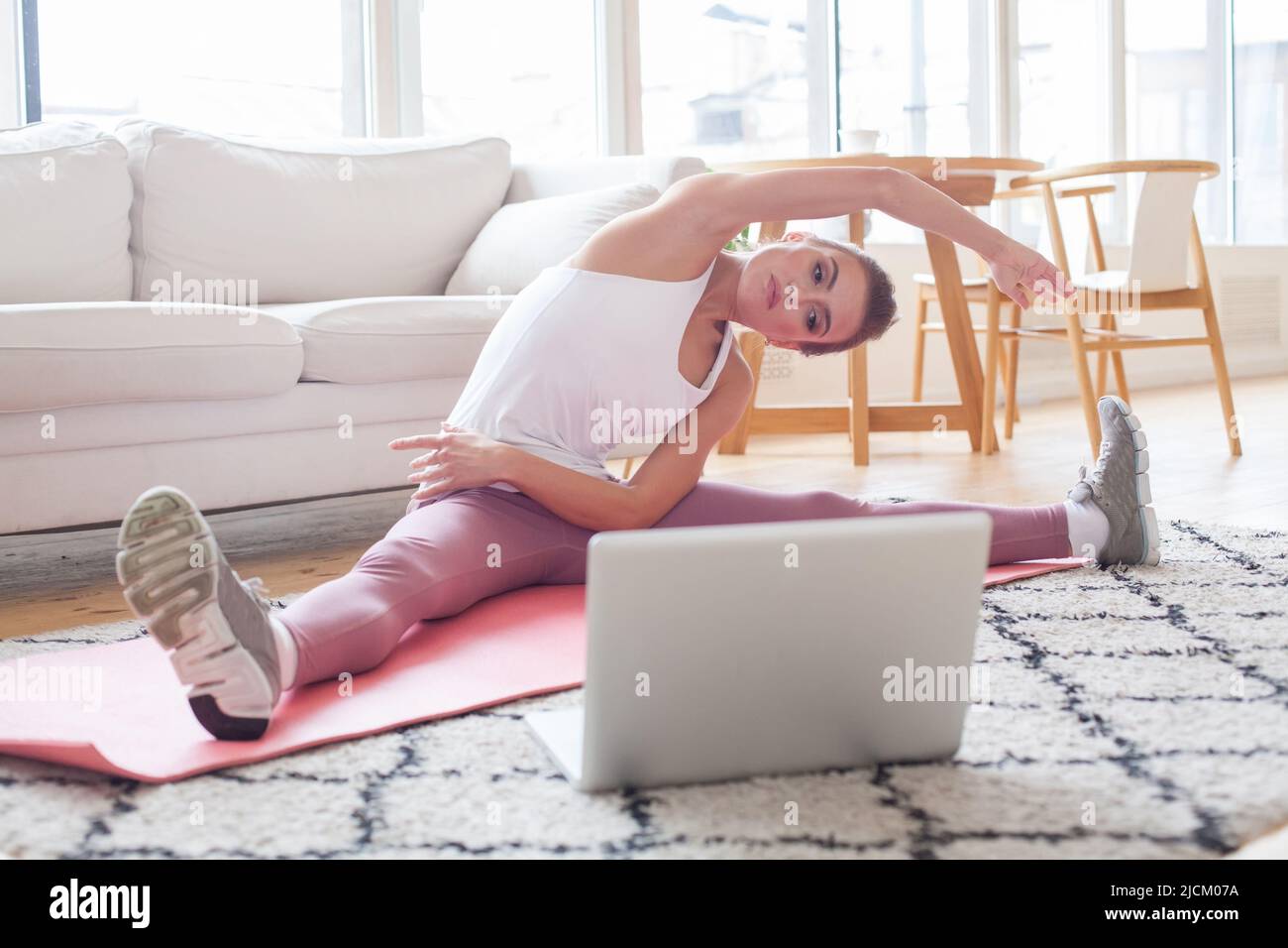 Perfect fitness woman make stretching exercises indoors at home with ...