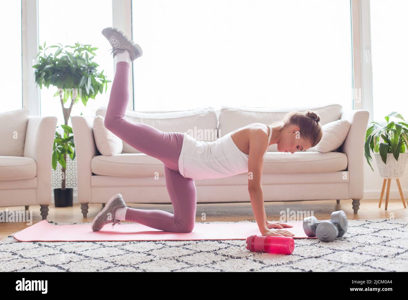 Sport and recreation concept. Young woman doing donkey kicks exercise ...