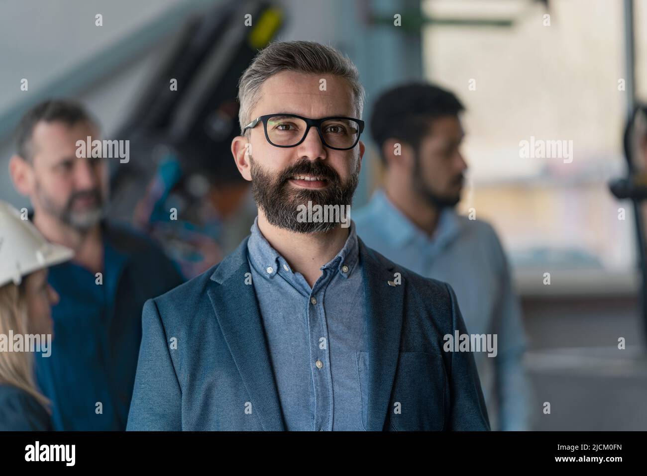Portrait of male chief engineer in modern industrial factory looking at ...
