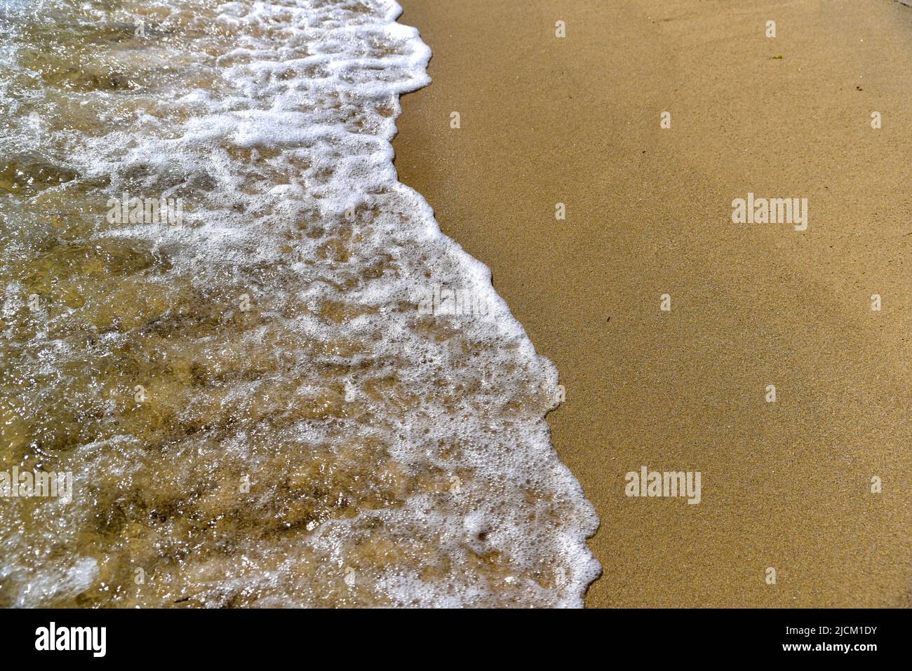 Tide on sand shore Stock Photo - Alamy
