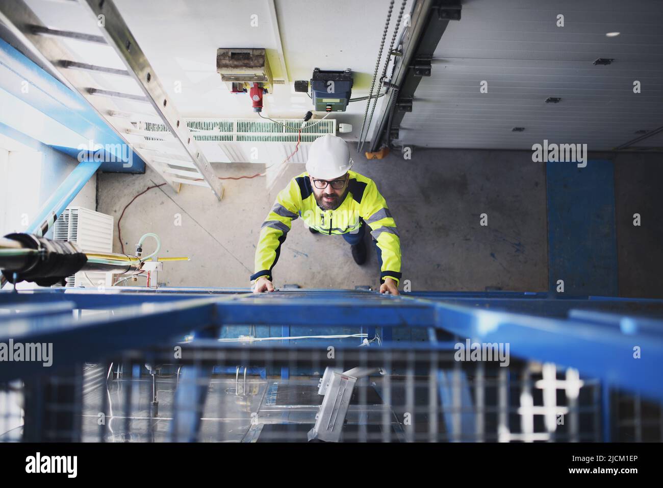 Top view of engineer in industrial factory climbing up the ladder Stock ...