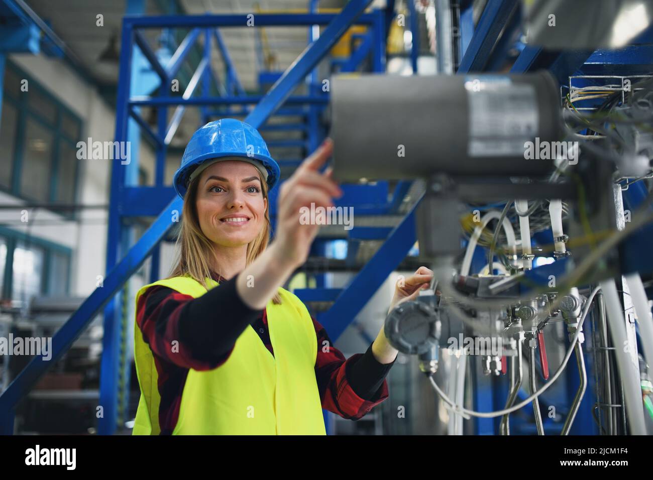 Portrait of female engineer working in industrial factory Stock Photo ...