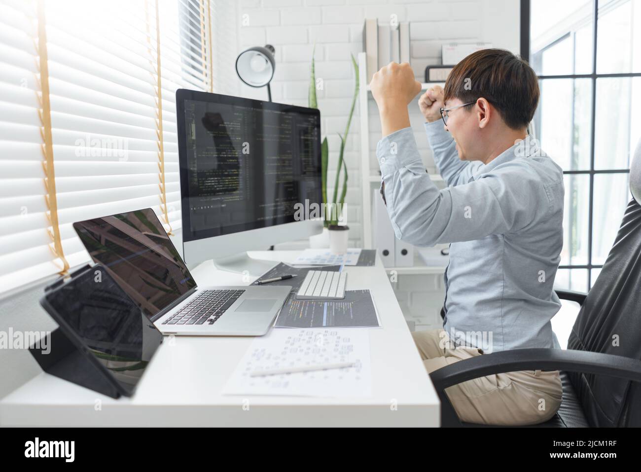 Software development concept, Male programmer excited and raise arms after successful ...