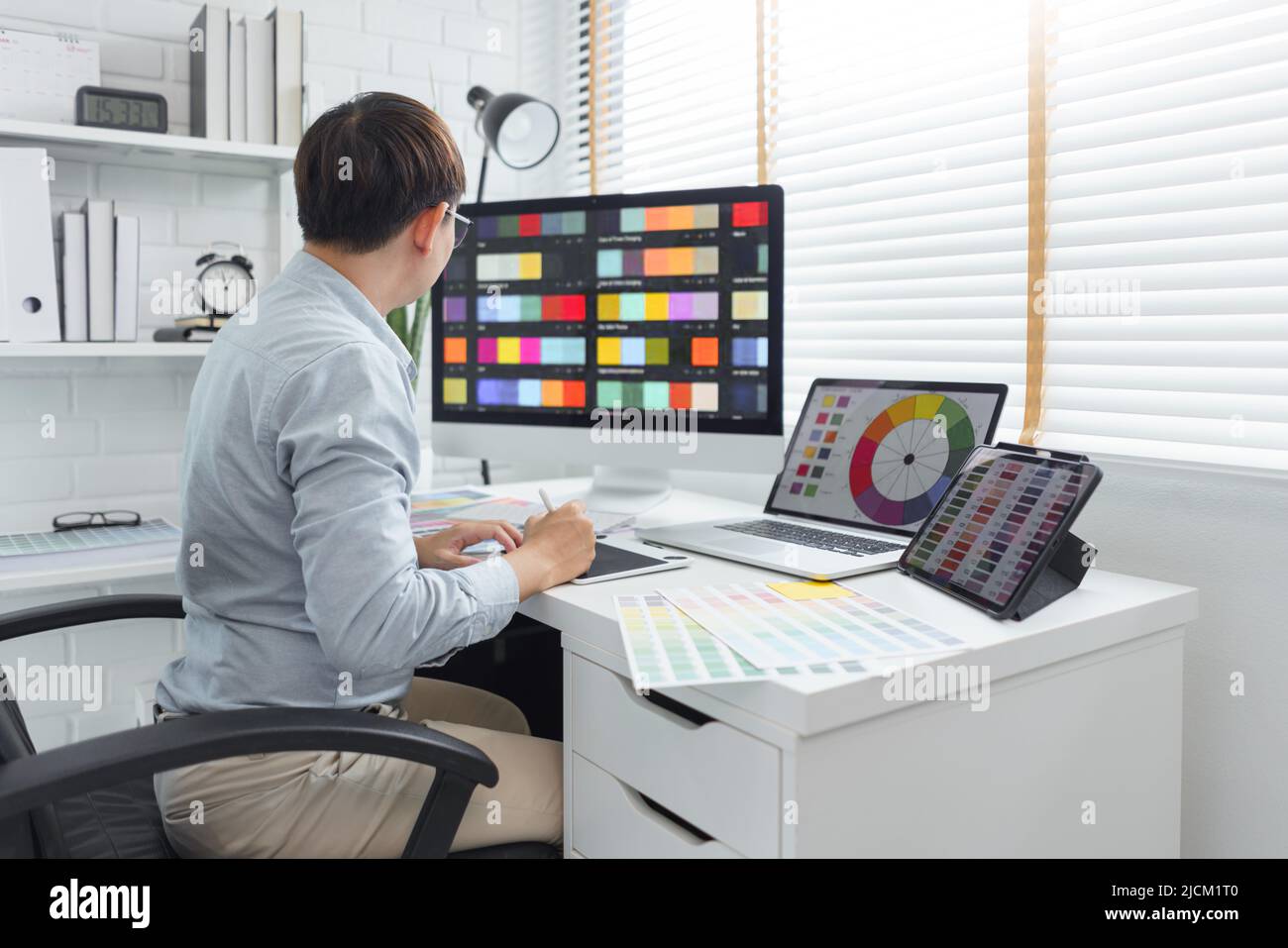 Creativity concept, Male graphic designer using tablet and looking ...