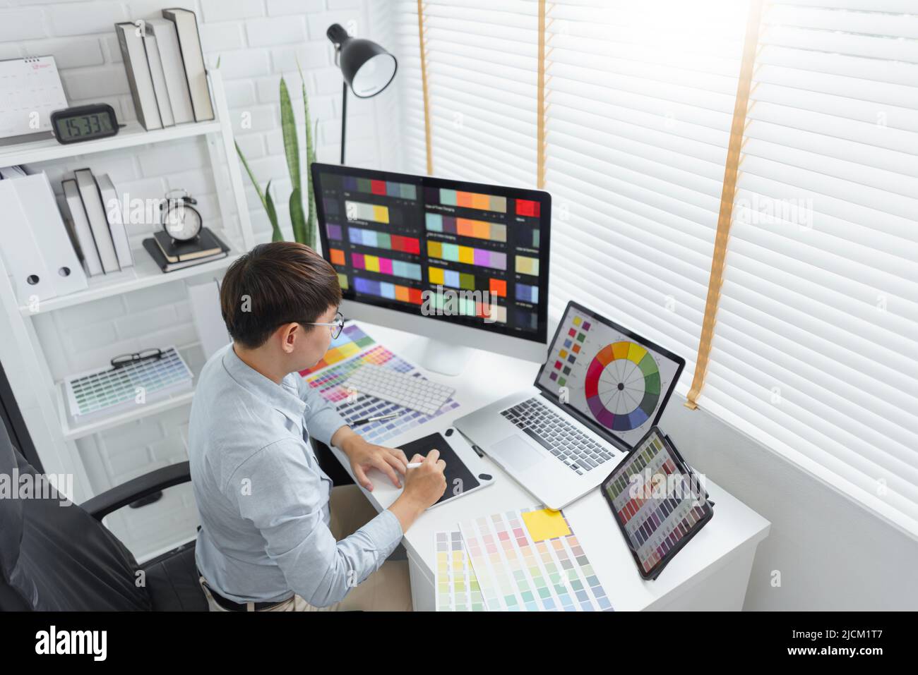 Creativity concept, Male graphic designer using tablet and looking ...