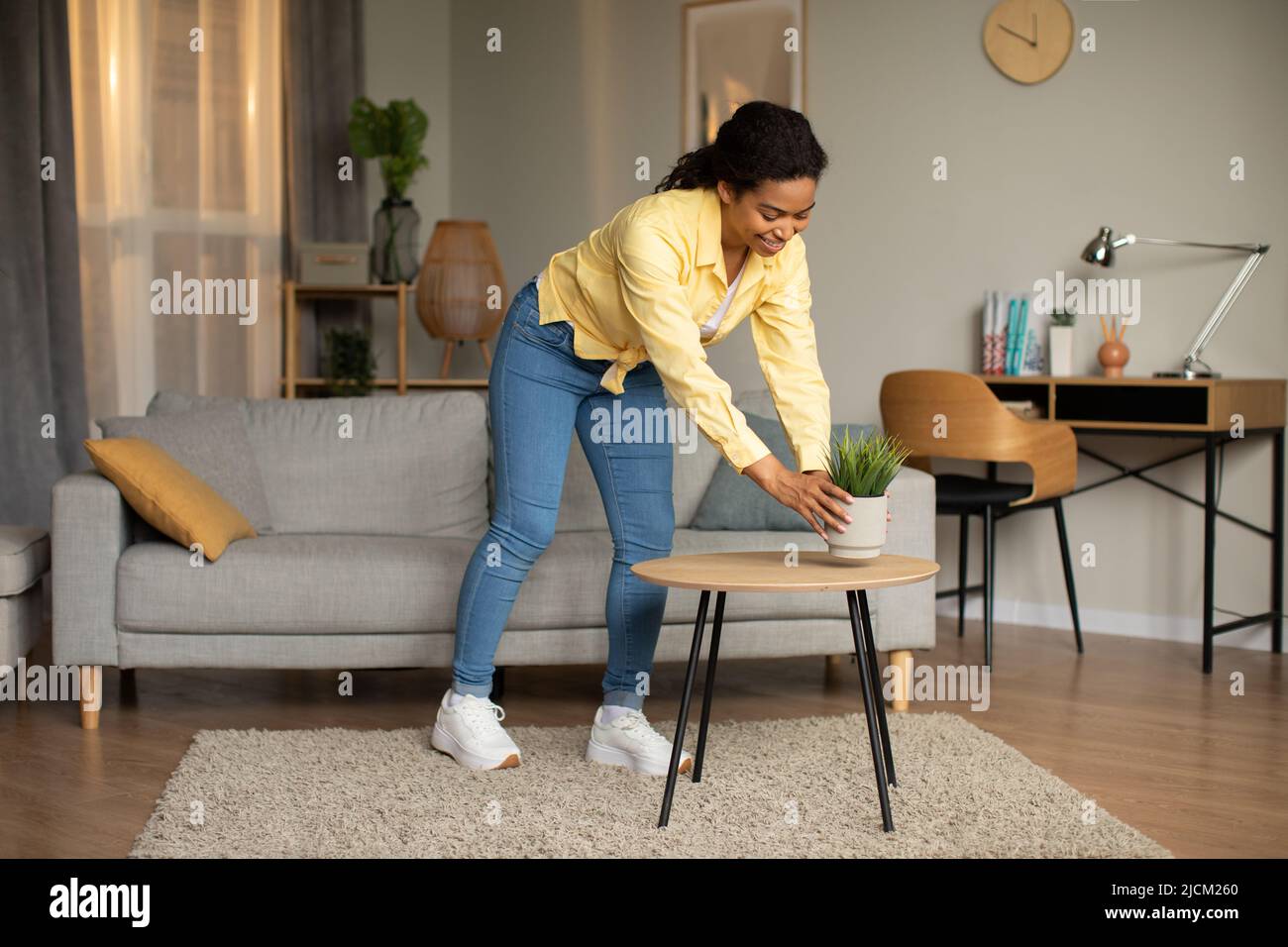 Black Female Putting Green Plant In Pot On Table Indoor Stock Photo - Alamy