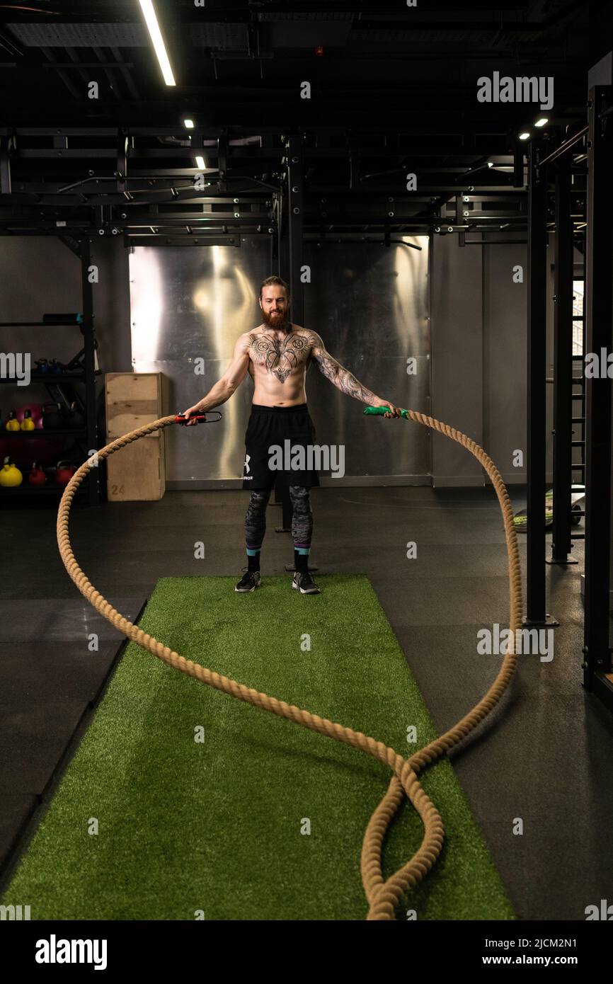 Rope training man warehouse fitness gym muscular exercising exercise ...